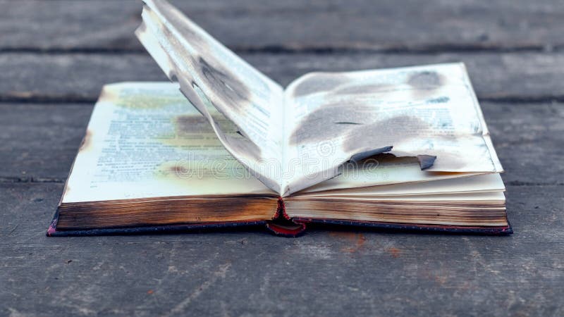 A Charred Open Book on a Wooden Table. a Book Saved from a Fire Stock ...