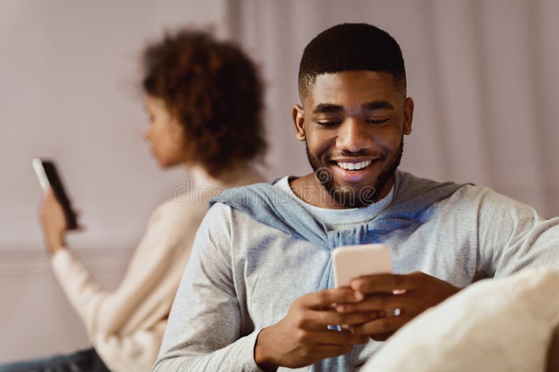Cheating. Black Man Chatting on Phone and Smiling Stock Photo - Image ...