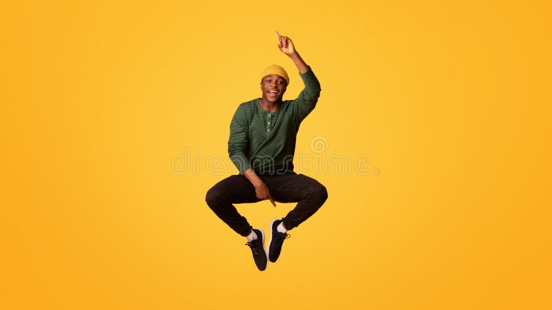 Check this. Cheerful Young Black Guy Pointing Up and Down while Jumping ...