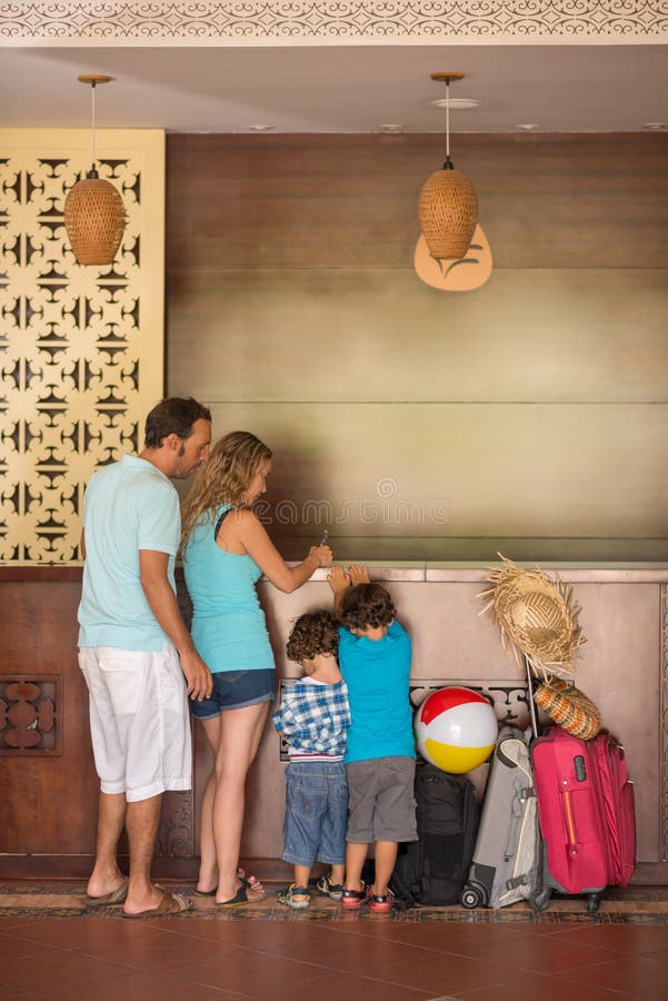 Family Checking In At Resort Reservation Counter Stock Image - Image of ...