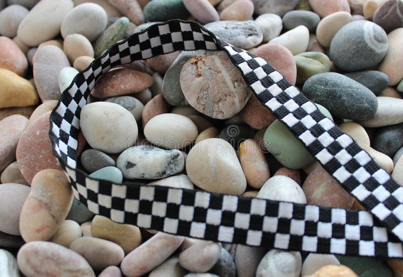 Checkered Ribbon in Loop Form on a Colored Pebbles Stock Photo - Image ...