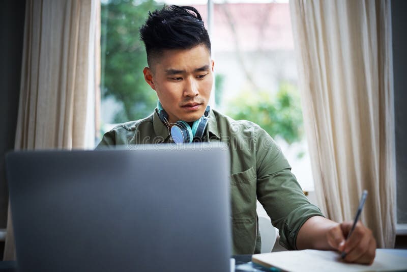 Checking Back To His Design Notes. a Handsome Young Man Taking Notes ...