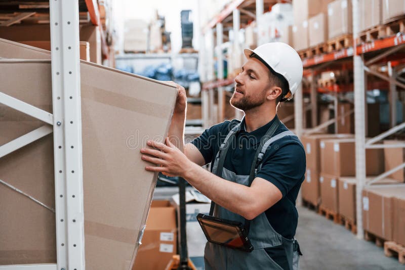 Checking the Box. Employee in Uniform is Working in the Storage at ...