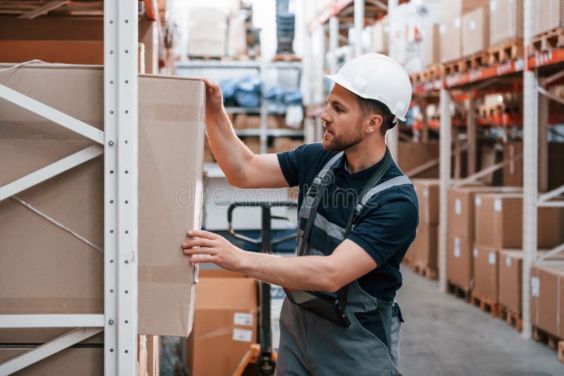 Checking the Box. Employee in Uniform is Working in the Storage at ...
