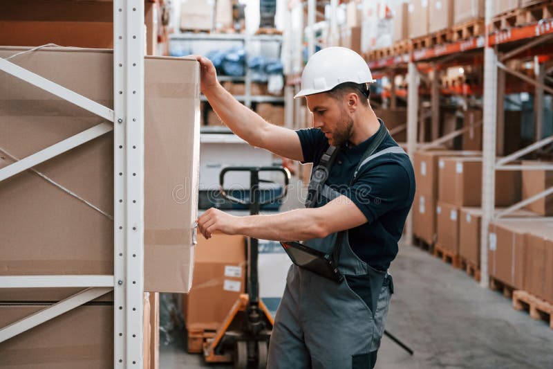 Checking the Box. Employee in Uniform is Working in the Storage at ...