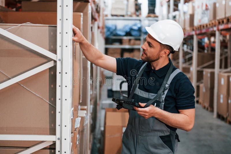Checking the Box. Employee in Uniform is Working in the Storage at ...