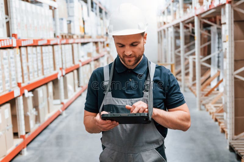 Checking Data in the Tablet. Employee in Uniform is Working in the ...