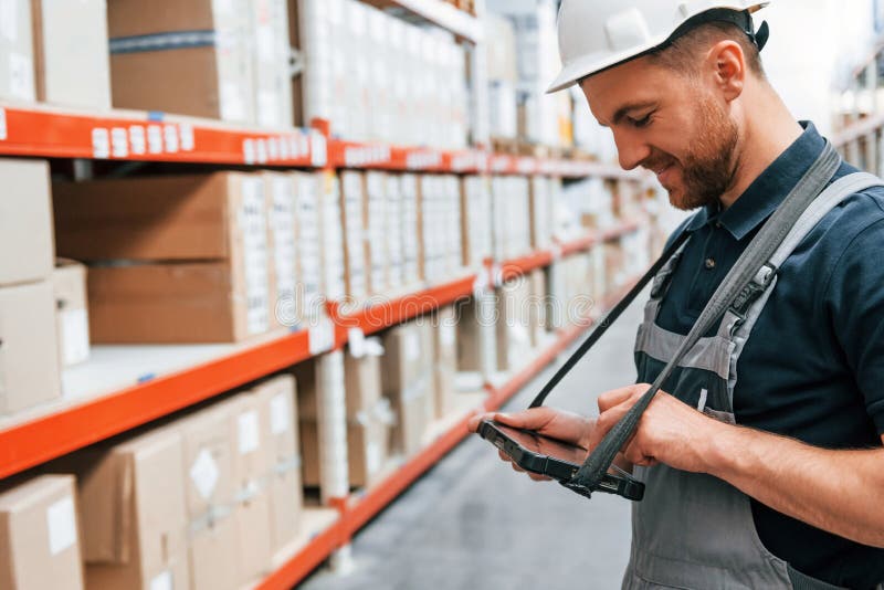 Checking Data in the Tablet. Employee in Uniform is Working in the ...