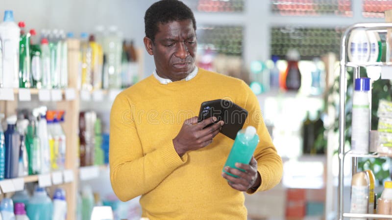 Checking Expiration Date of Shampoo or Shower Gel - Male Shopper Scans QR Code on Label of ...