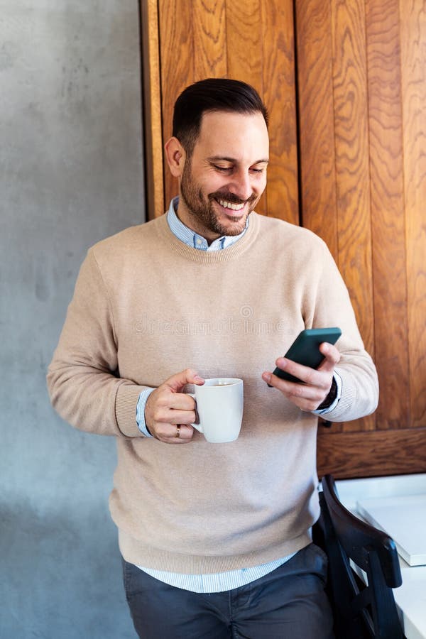 Checking His Messages Over Coffee. Man Using a Smart Phone while ...