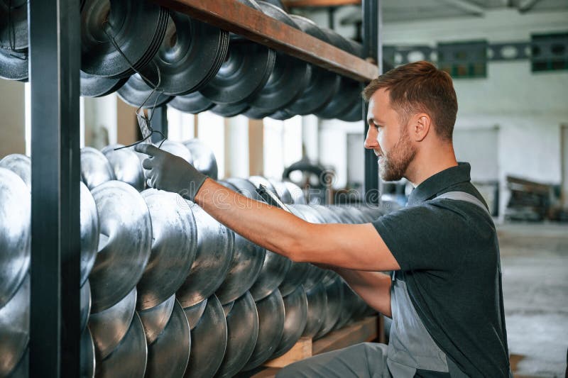 Checking Number of Parts. Man in Uniform is in Workstation Developing ...