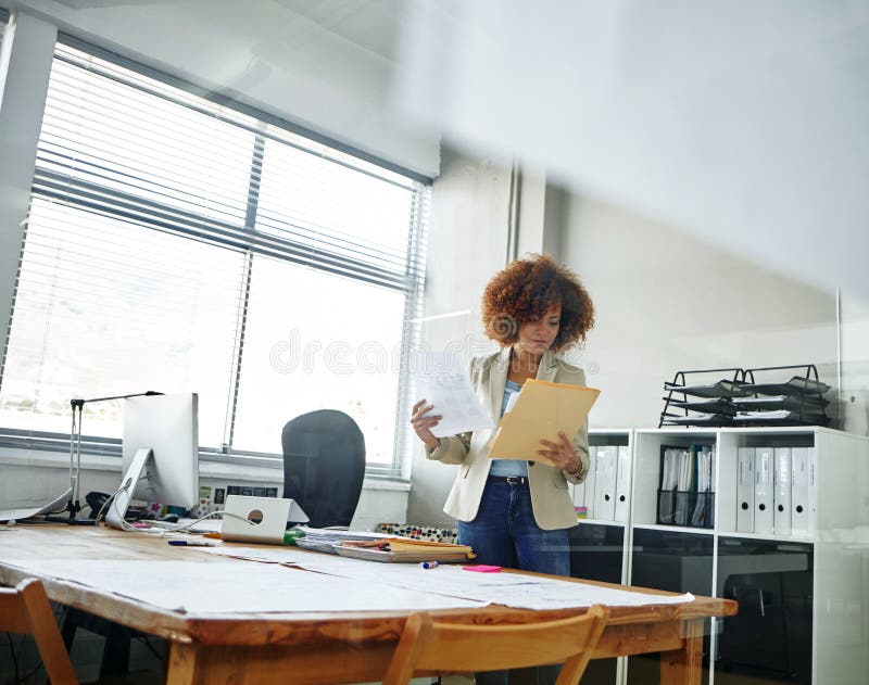 Checking the Paperwork. a Beautiful Young Businesswoman Looking Over ...