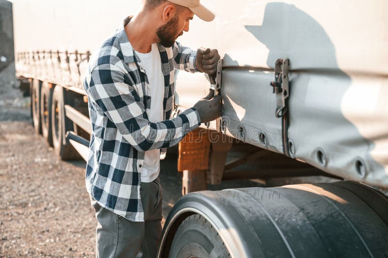 Checking the Ropes. Young Truck Driver is with His Vehicle at Daytime ...