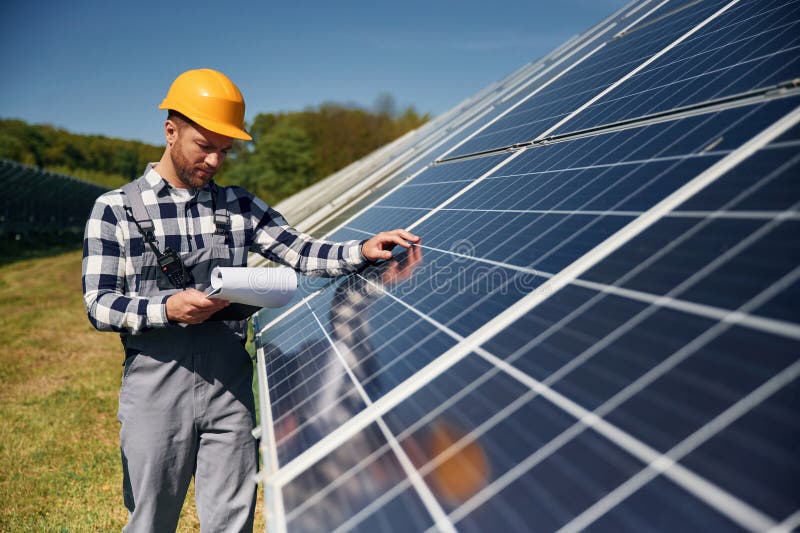 Checking the Surface. Engineer with Photovoltaic Solar Panels Outdoors ...