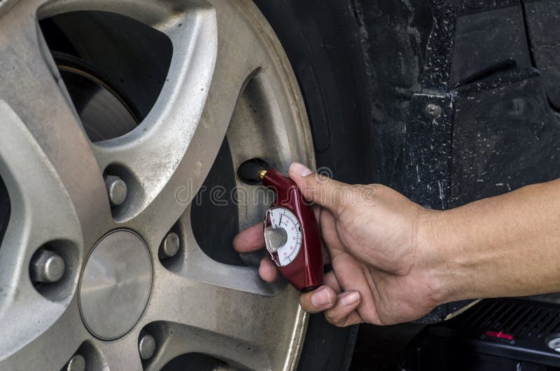 Checking Tires with a Hand Held Tire Pressure Gauge. Stock Image ...