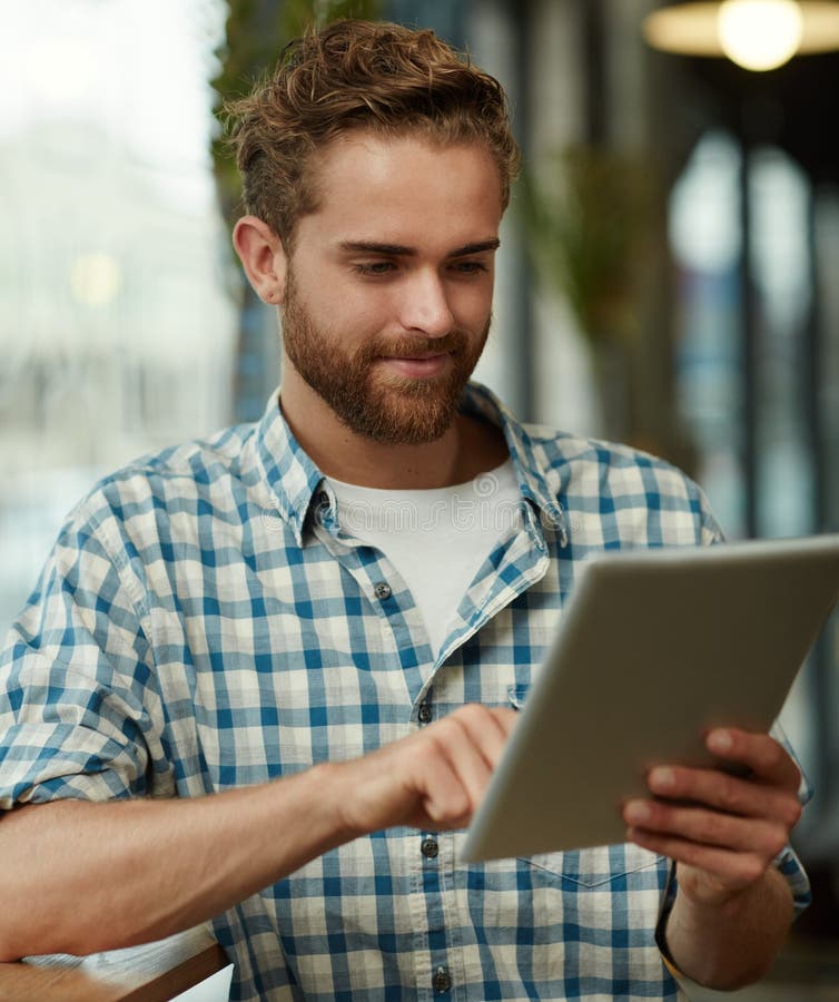 Checking Up on His Schedule. a Young Man Using a Digital Tablet in a ...