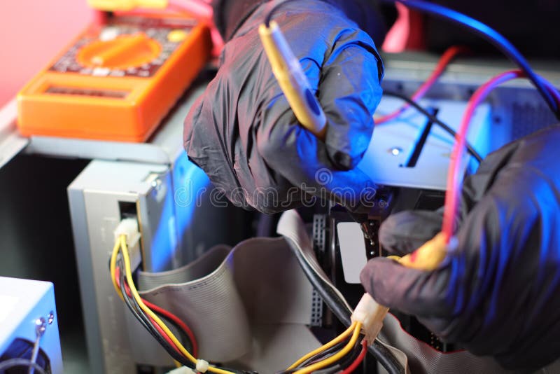 Checking the Voltage with an Ammeter in an Old Computer on the Table ...