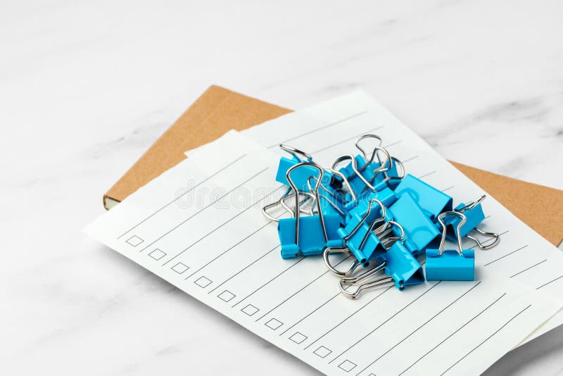 Checklist Paper with Heap of Binder Clips on Marble Table Background ...