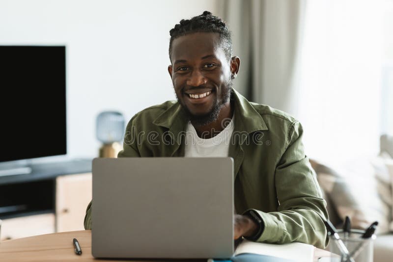 Cheerful African American Guy Programmer Sitting at Workdesk at Home, Male Freelancer Sitting in ...