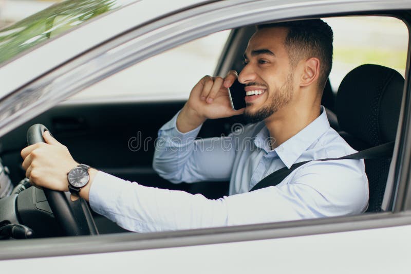 Cheerful Arab Man Talking on Cellphone while Driving Car Stock Photo ... Cheerful Arab Man Talking on Cellphone while Driving Car Stock Photo ...