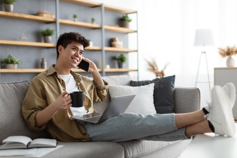 Cheerful Asian Guy Working and Talking on Phone at Home Stock Image ...
