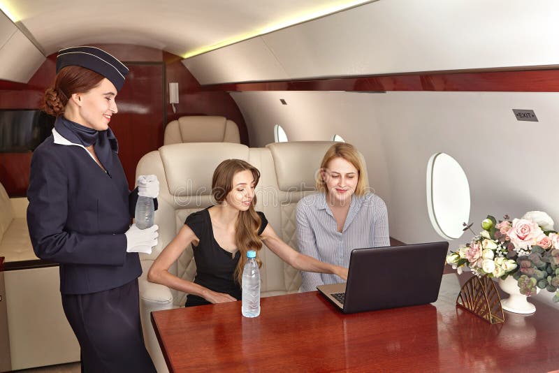 Air Hostess Inside Airplane Serves First Class Passengers. Stock Image ...