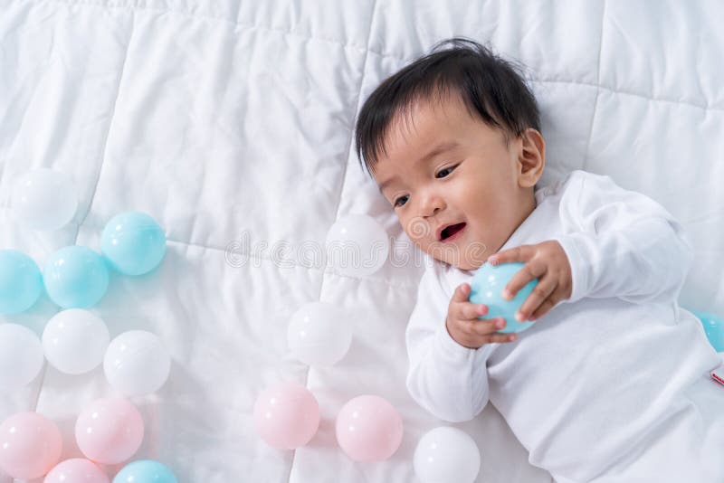 Cheerful Baby Playing Color Ball on Bed Stock Image - Image of ...