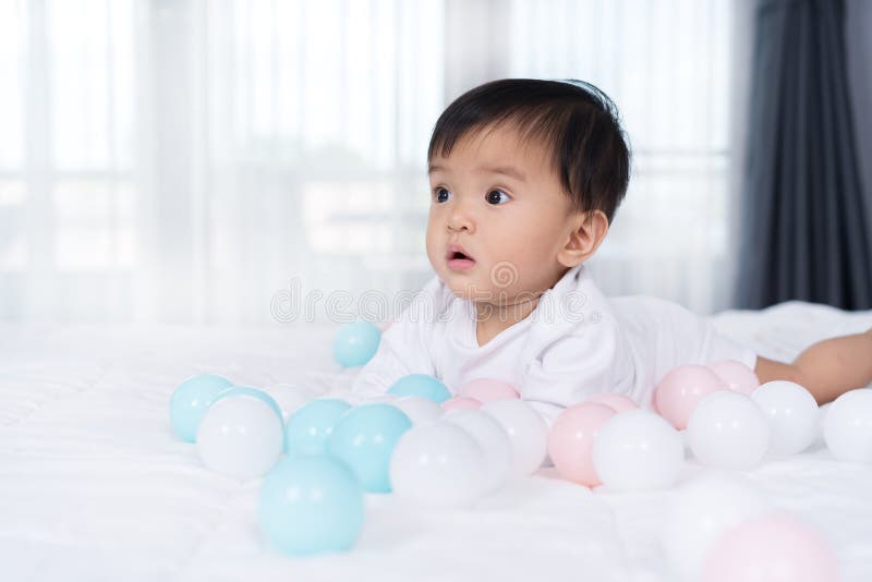 Cheerful Baby Playing Color Ball on Bed Stock Photo - Image of child ...