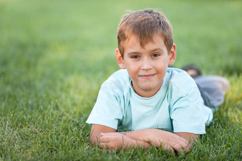 Cheerful Boy Lying on the Lawn Stock Photo - Image of dreamer, green ...
