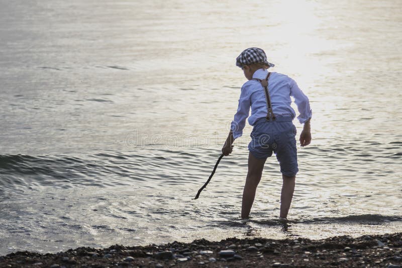 A Cheerful Boy Throwing Rocks at Sea Stock Image - Image of throwing ...