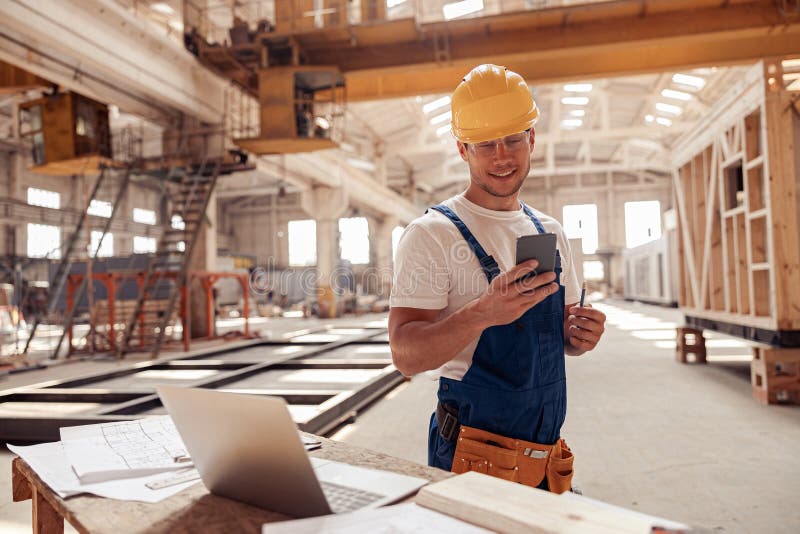 Cheerful Builder Using Smartphone at Construction Site Stock Image ...