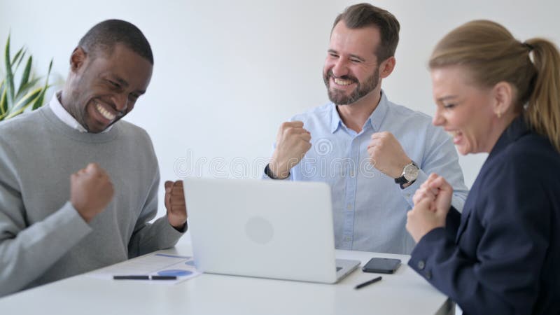 Cheerful Business People Celebrating Success while Using Laptop in ...