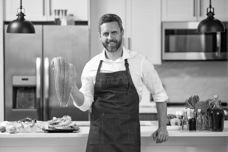 Cheerful Chef Man Cooking Fish Salmon. Chef Man Cooking Fish in the ...