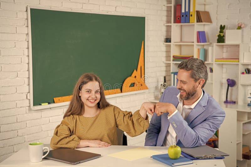 Cheerful Child Study in Classroom with Tutor. Fist To Fist Stock Photo ...