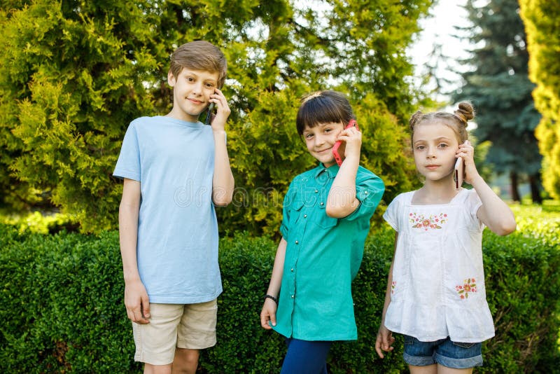 Cheerful Children are Talking on Their Smartphone on Walking Outside ...