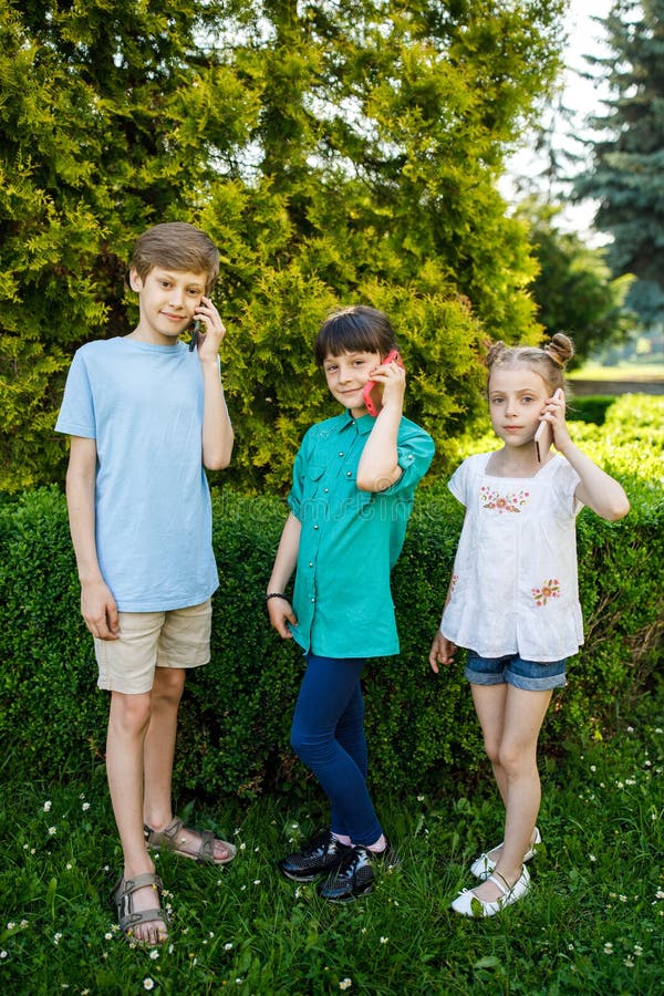 Cheerful Children are Talking on Their Smartphone on Walking Outside ...