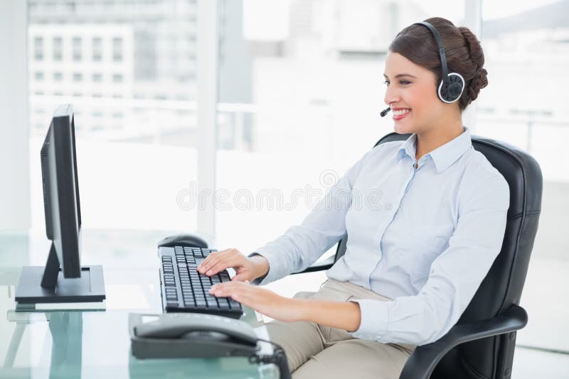 Cheerful Classy Brown Haired Operator Using Her Computer Stock Image ...