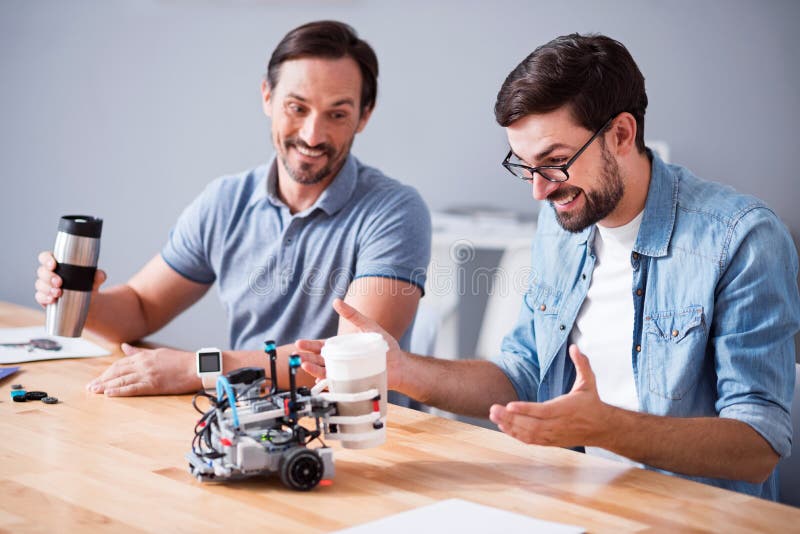 Cheerful Colleagues Testing Robot Stock Photo - Image of involved ...