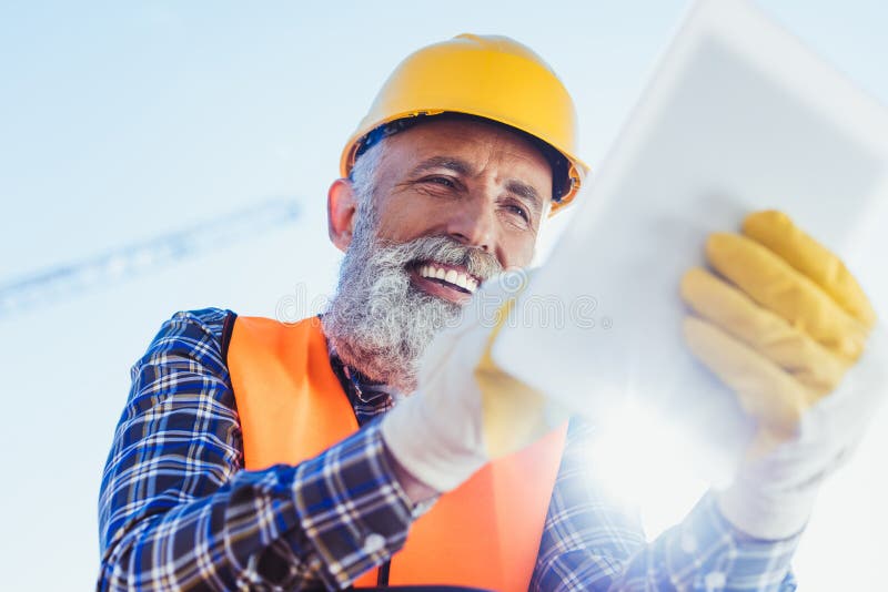 Cheerful Construction Worker in Reflective Vest and Hardhat Using Stock ...