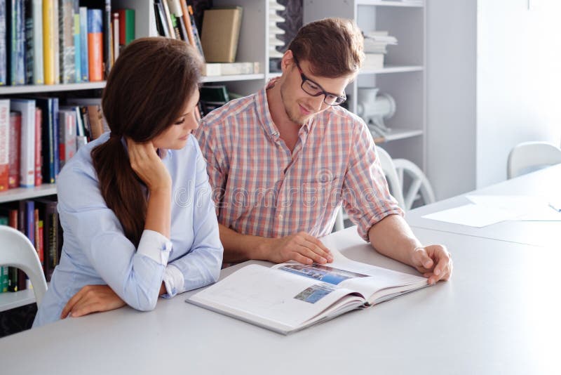 Cheerful Couple of Engineers Having Fun Reading a Book in a Architect ...