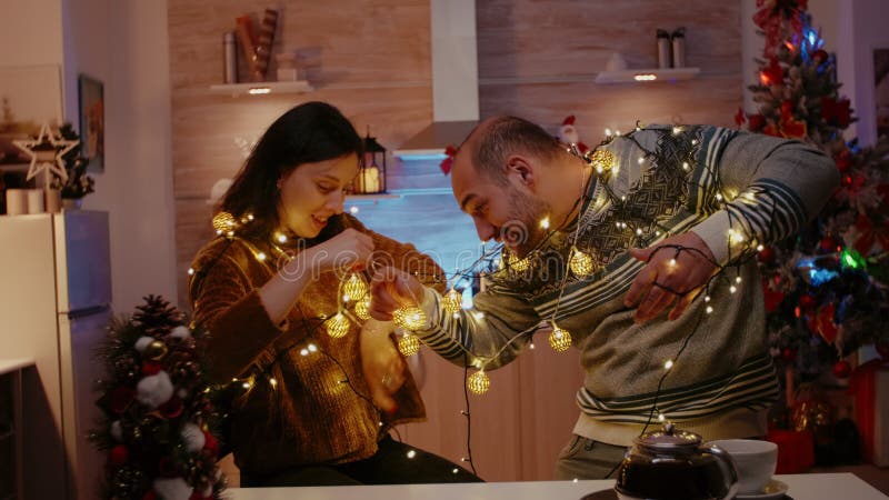 Cheerful Couple Getting Tangled in String of Twinkle Lights Stock Video ...