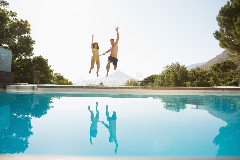 Cheerful Couple Jumping into Swimming Pool Stock Photo - Image of full ...