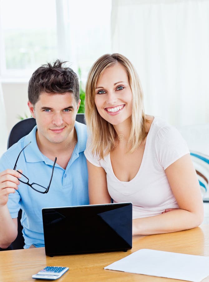 Cheerful Couple Using a Laptop Sitting Together Stock Photo - Image of ...