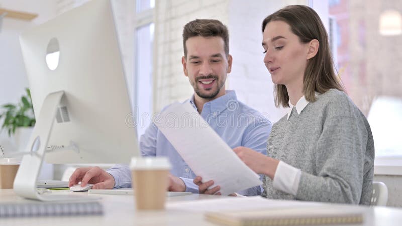 Cheerful Creative Team Reading Documents and Working on Desktop Stock ...