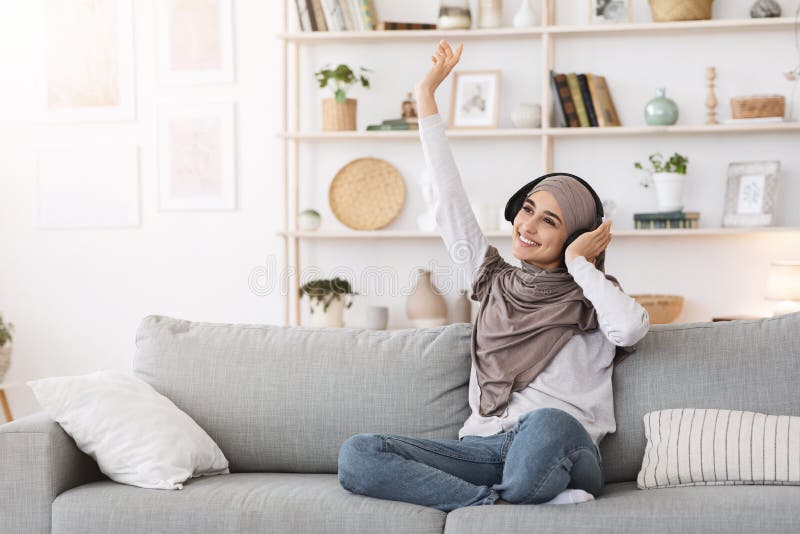 Cheerful Day. Positive Arabic Girl in Hijab Listening Music in Wireless ... Cheerful Day. Positive Arabic Girl in Hijab Listening Music in Wireless ...