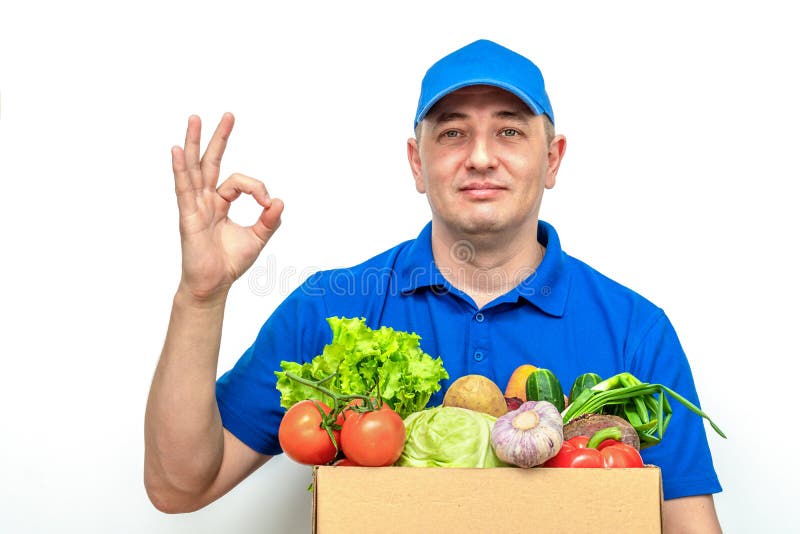 Cheerful Delivery Man of Fresh Vegetables in a Blue Uniform on a White ...