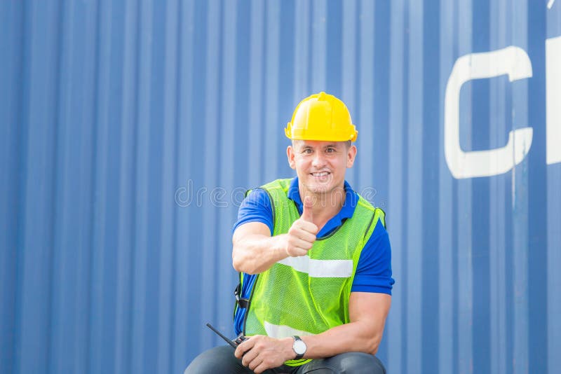 Cheerful Engineer Man Sitting and Smiling on Container Box with Giving ...