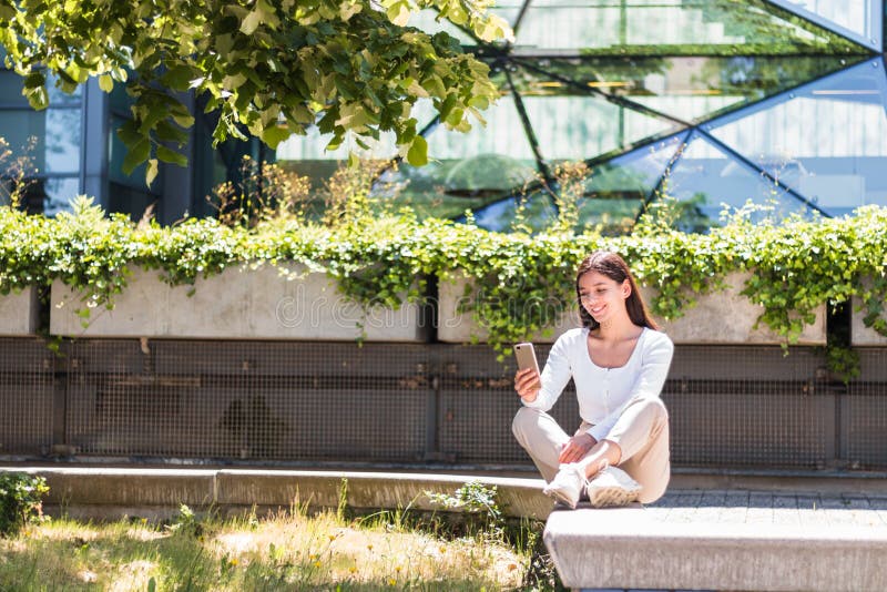 Cheerful Ethnicity Female University Student Texting on Her Cell Phone ...