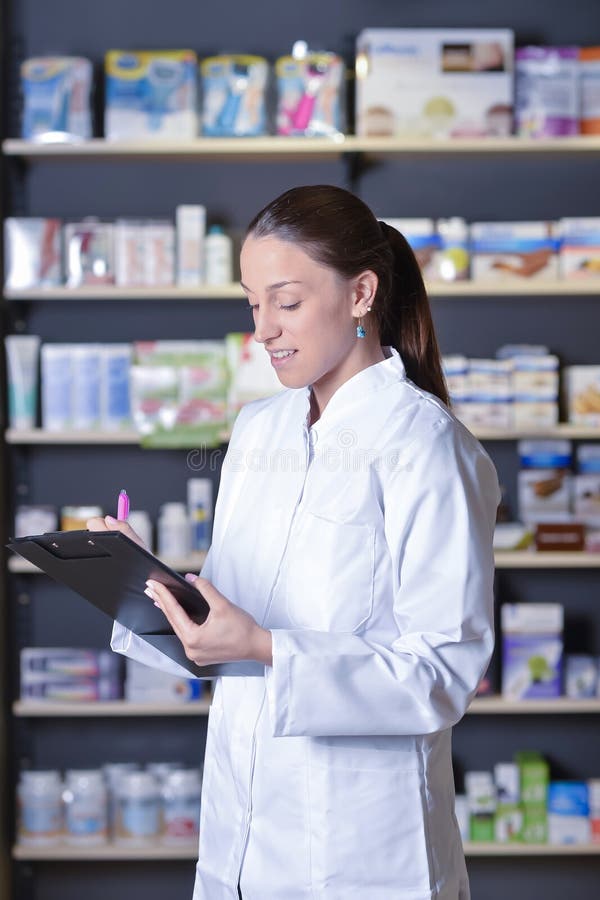 Cheerful Female Expert Pharmacist is Making Notes while Standing Stock ...