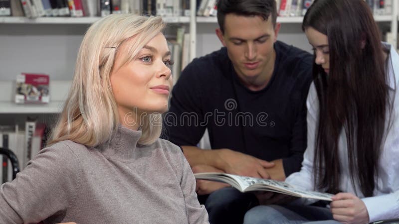 Cheerful Female Student Beaming at the Camera in a Vibrant Library Setting Stock Video - Video ...